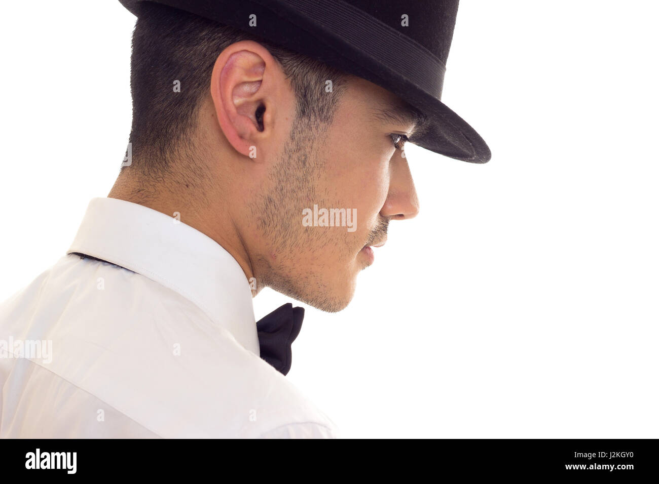 Elegant young man in white shirt with black bow-tie and black hat on ...