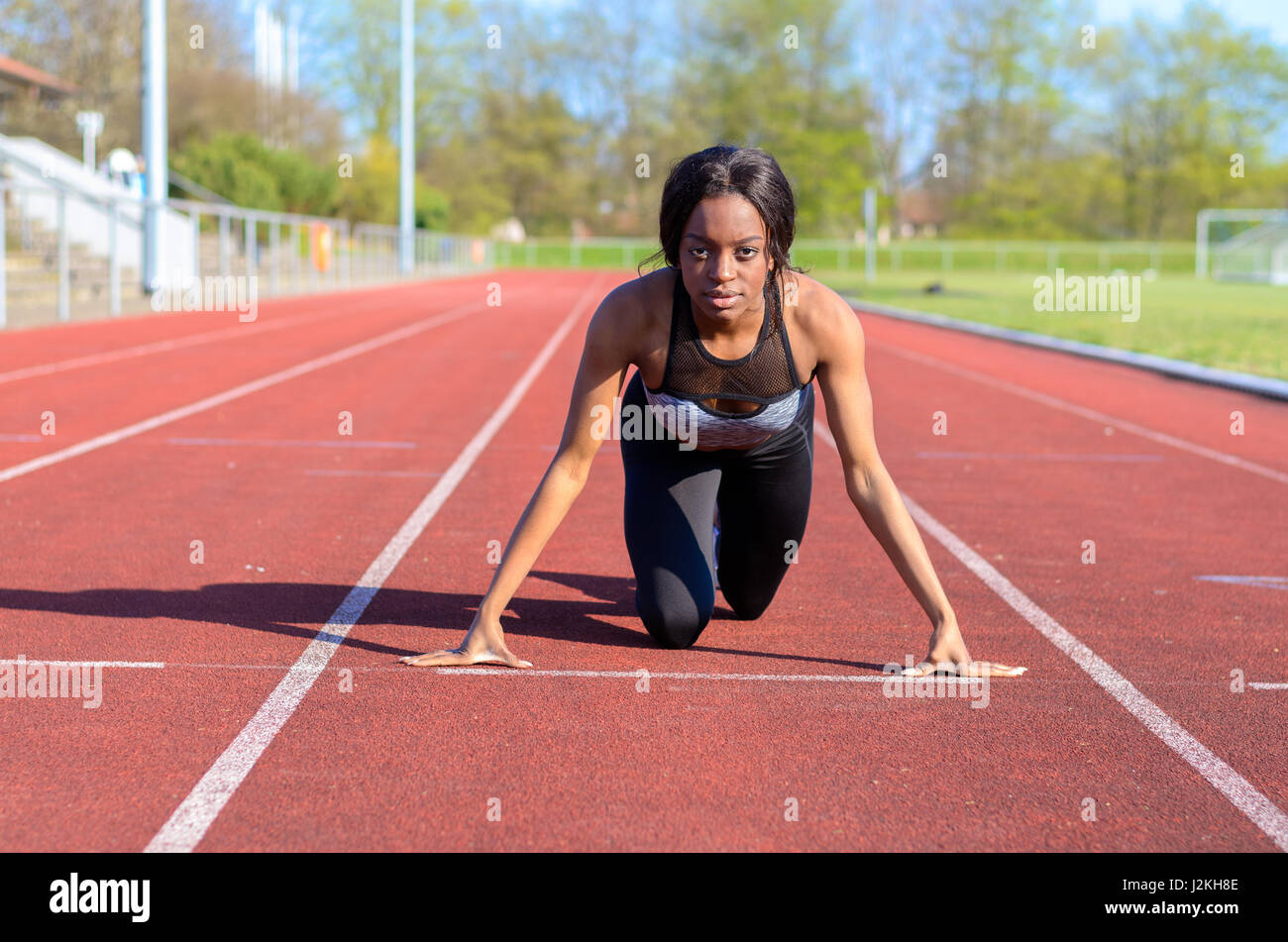 Young African woman doing sprint training on a sports track launching ...