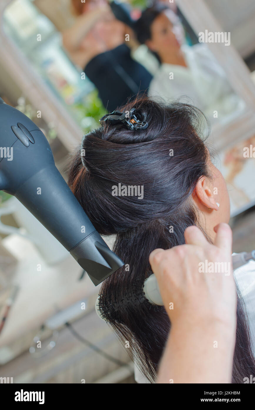 Brunette having her hair styled Stock Photo - Alamy