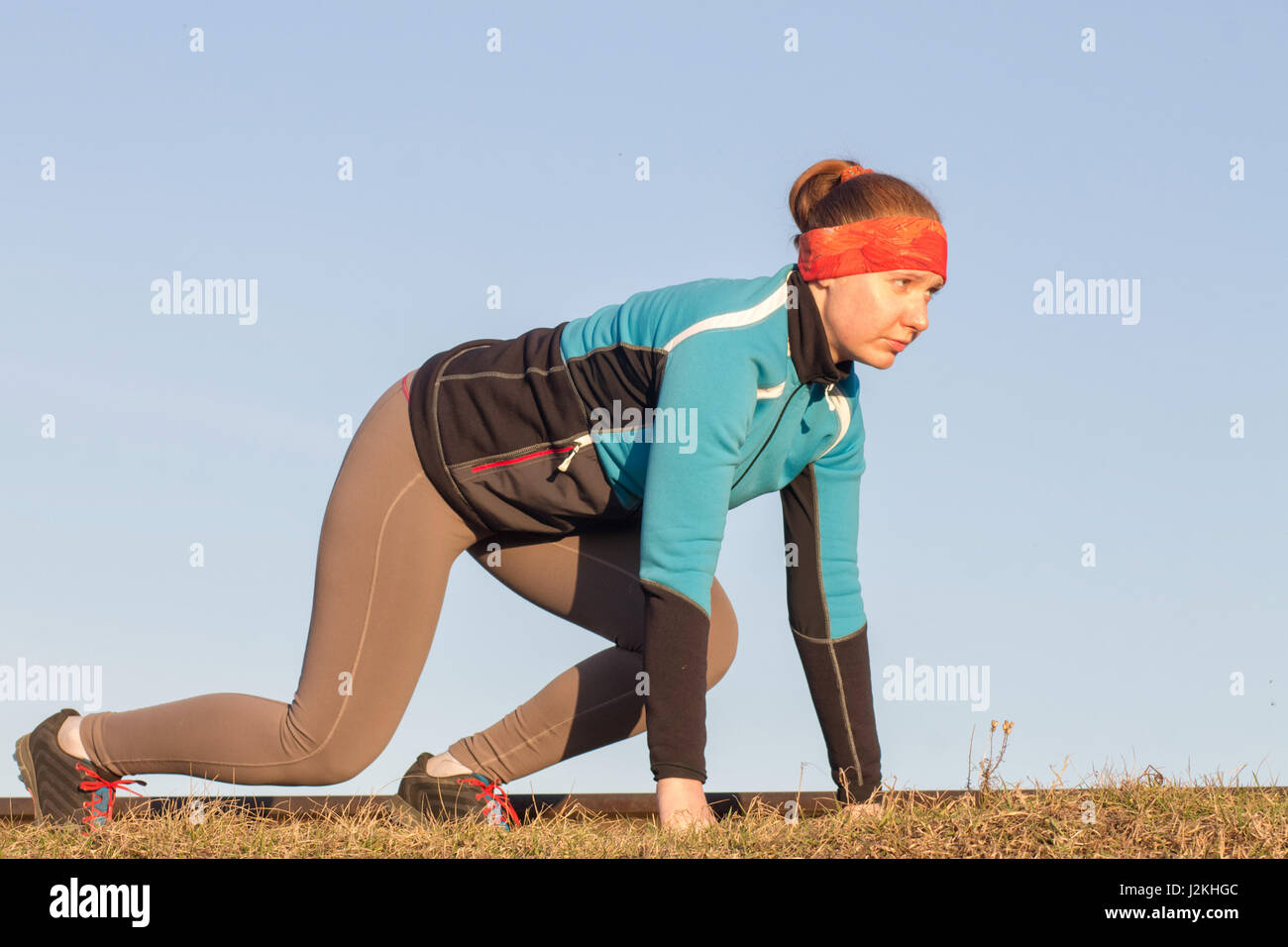 Young woman runner outdoor standing in start pose Stock Photo - Alamy