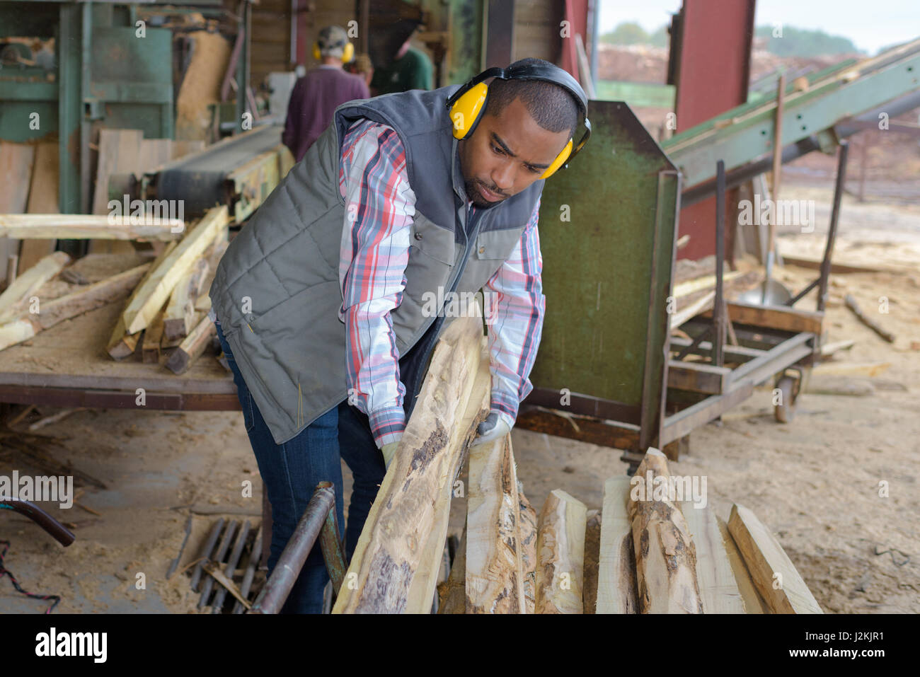 worker lifting some wood Stock Photo - Alamy
