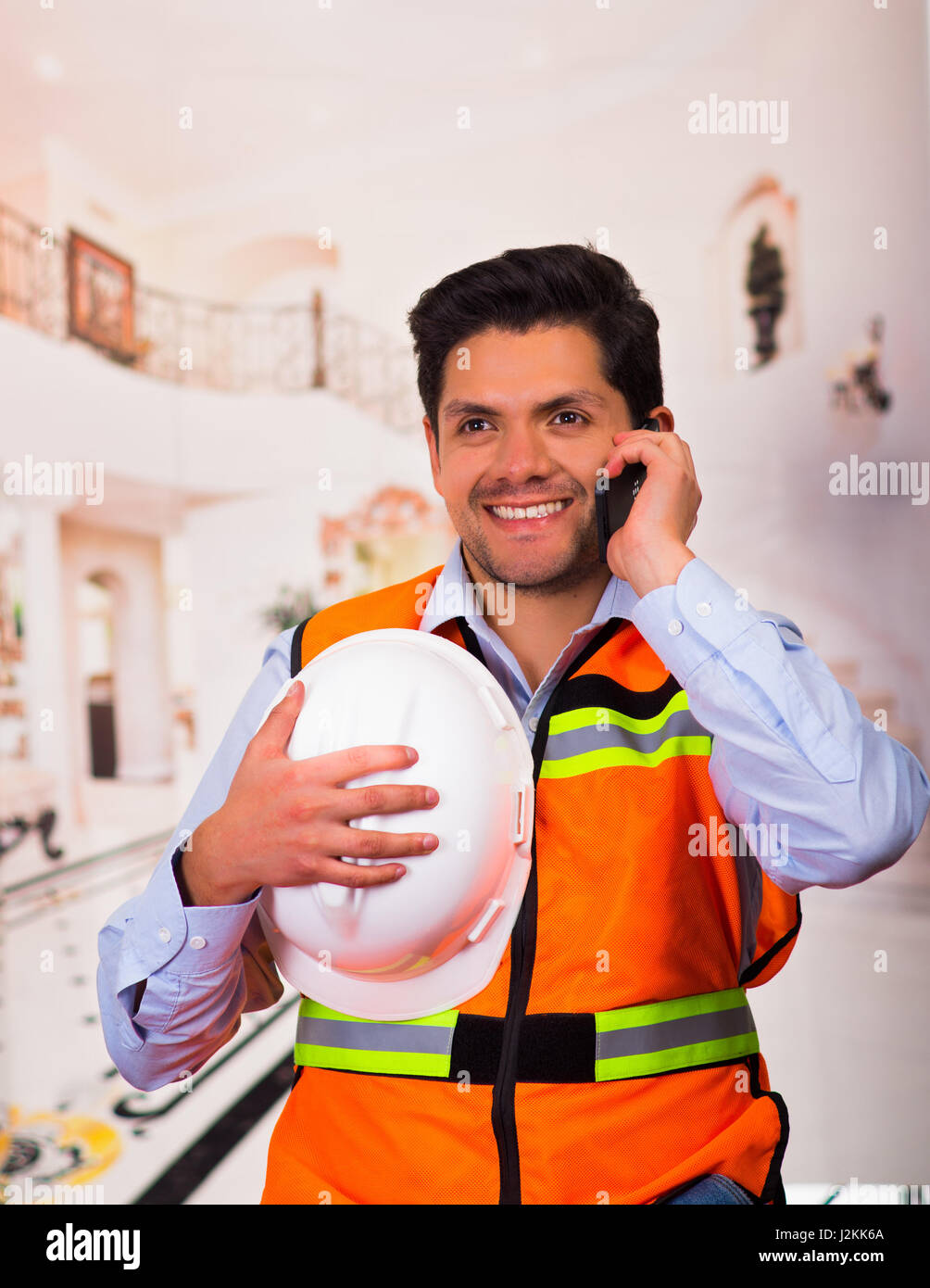 Smiling engineer with a helmet in his hand at construction site Stock ...