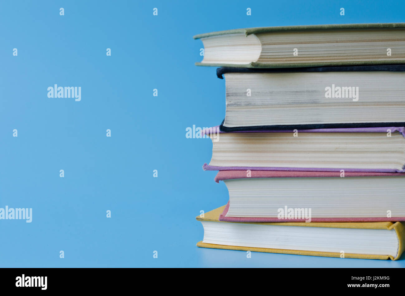 a stack of colorful books on a blue background in library Stock Photo ...