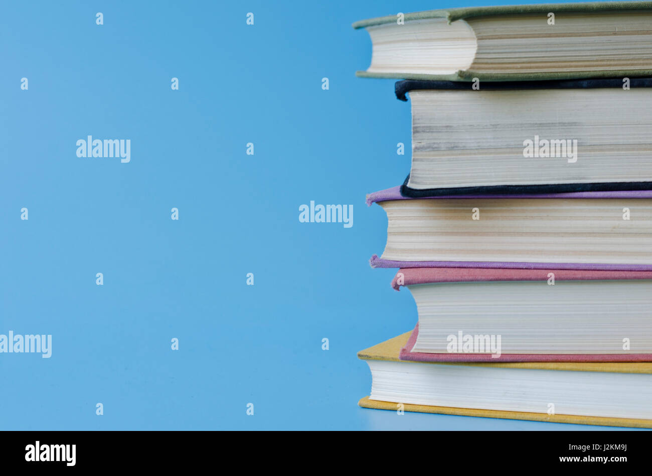 a stack of colorful books on a blue background in library Stock Photo ...