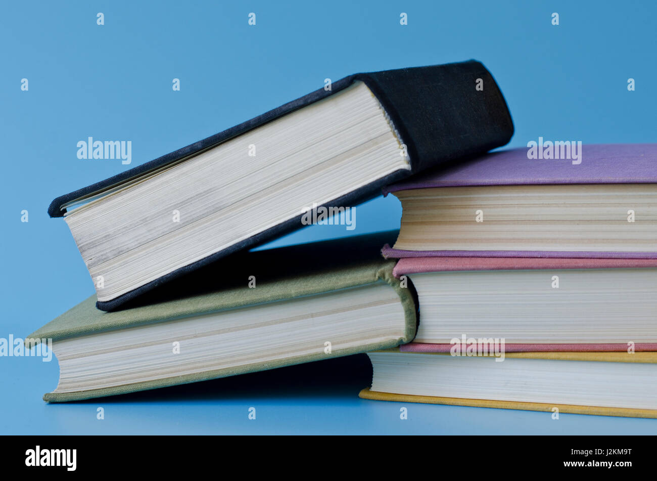 a stack of colorful books on a blue background in library Stock Photo ...