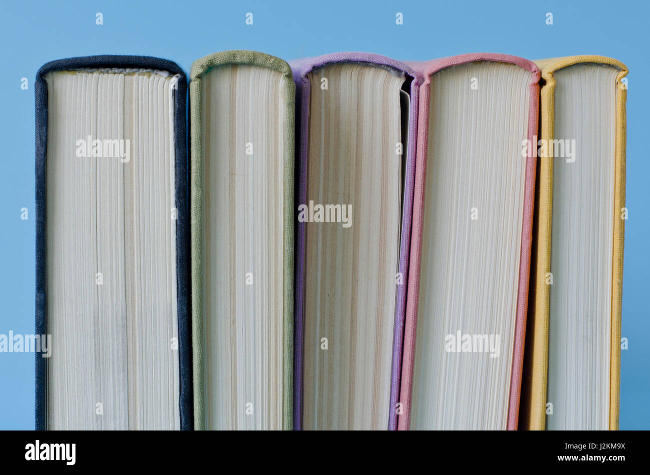 a stack of colorful books on a blue background in library Stock Photo ...