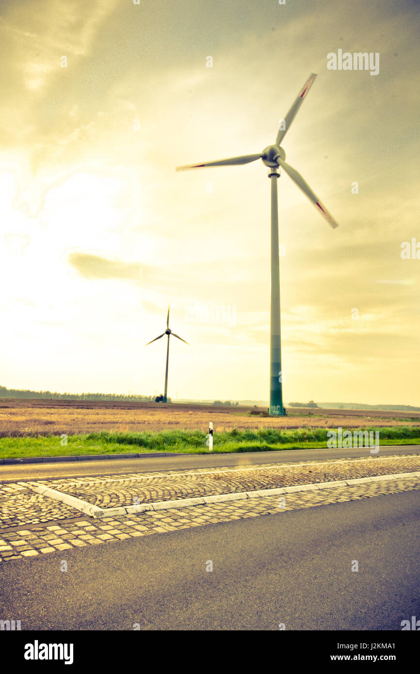Wind energy wheel close to a field. Walking on a road Stock Photo - Alamy