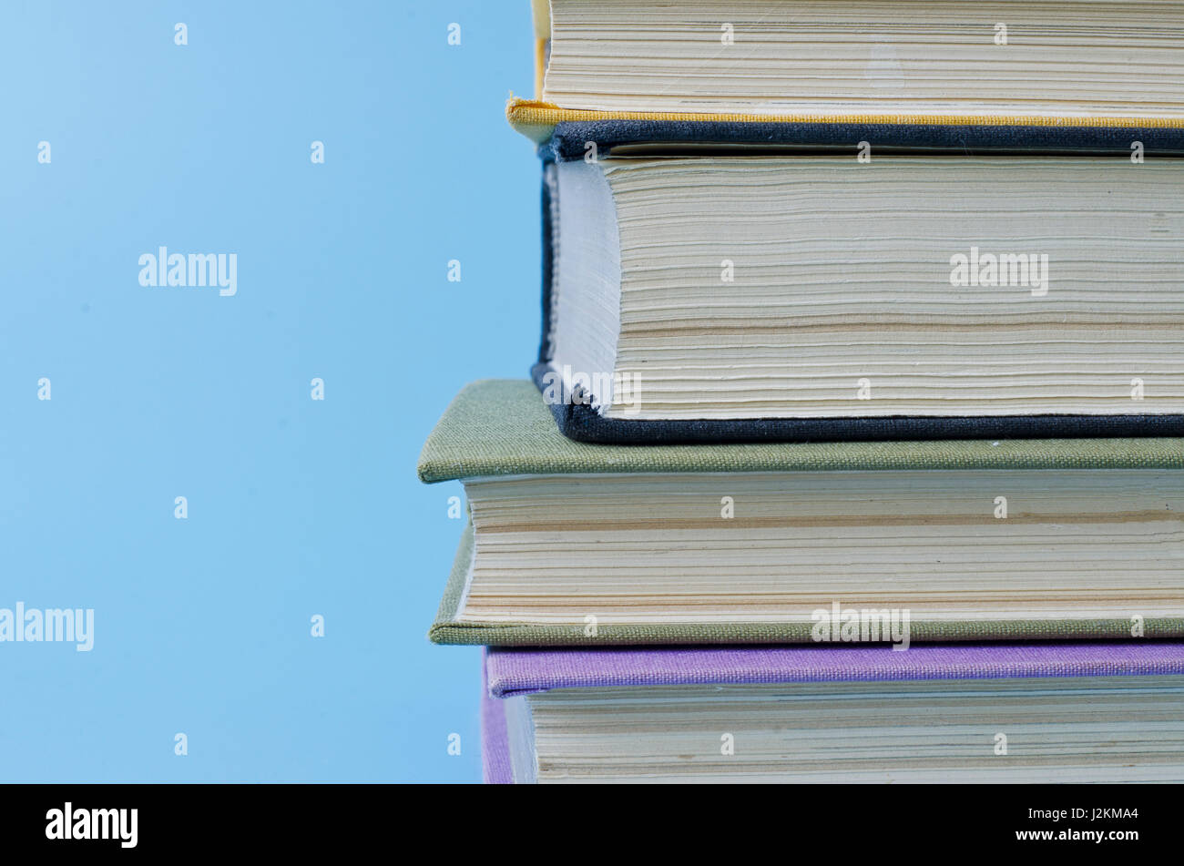 a stack of colorful books on a blue background in library Stock Photo ...