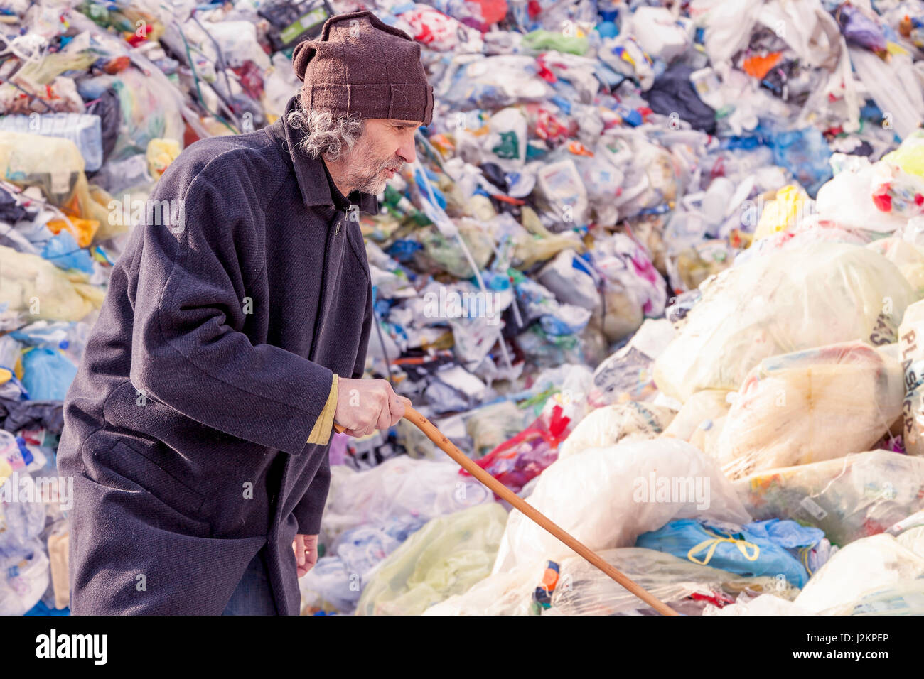 homeless man digs in the garbage Stock Photo - Alamy