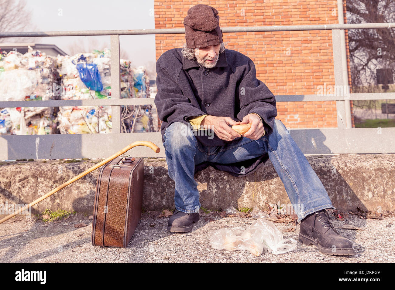 tramp eating bread sitting in landfills Stock Photo - Alamy