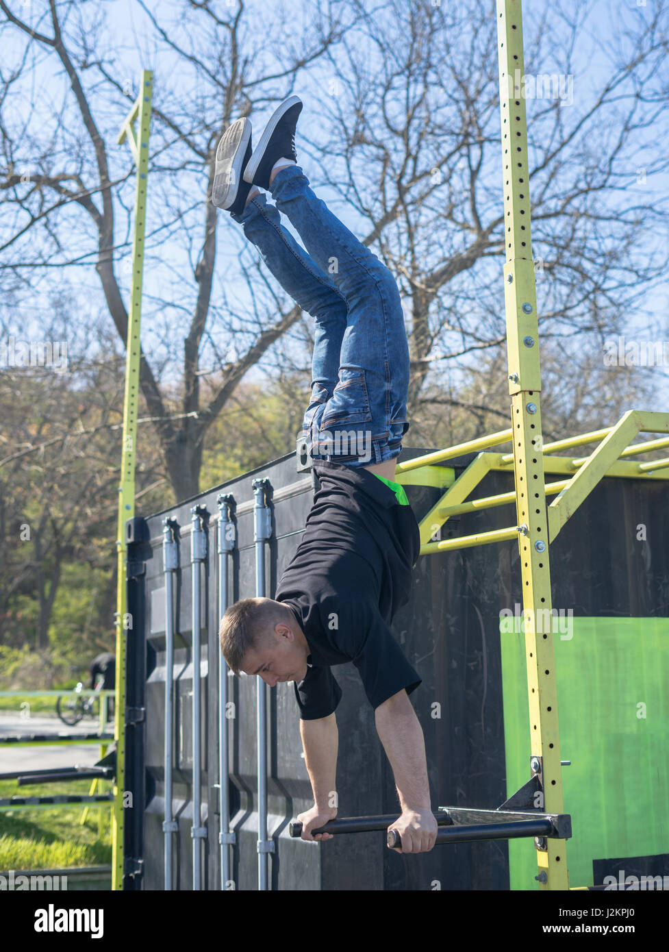Young Athlete doing a Hand Stand On Parallel Bars In An Outdoor Gym ...