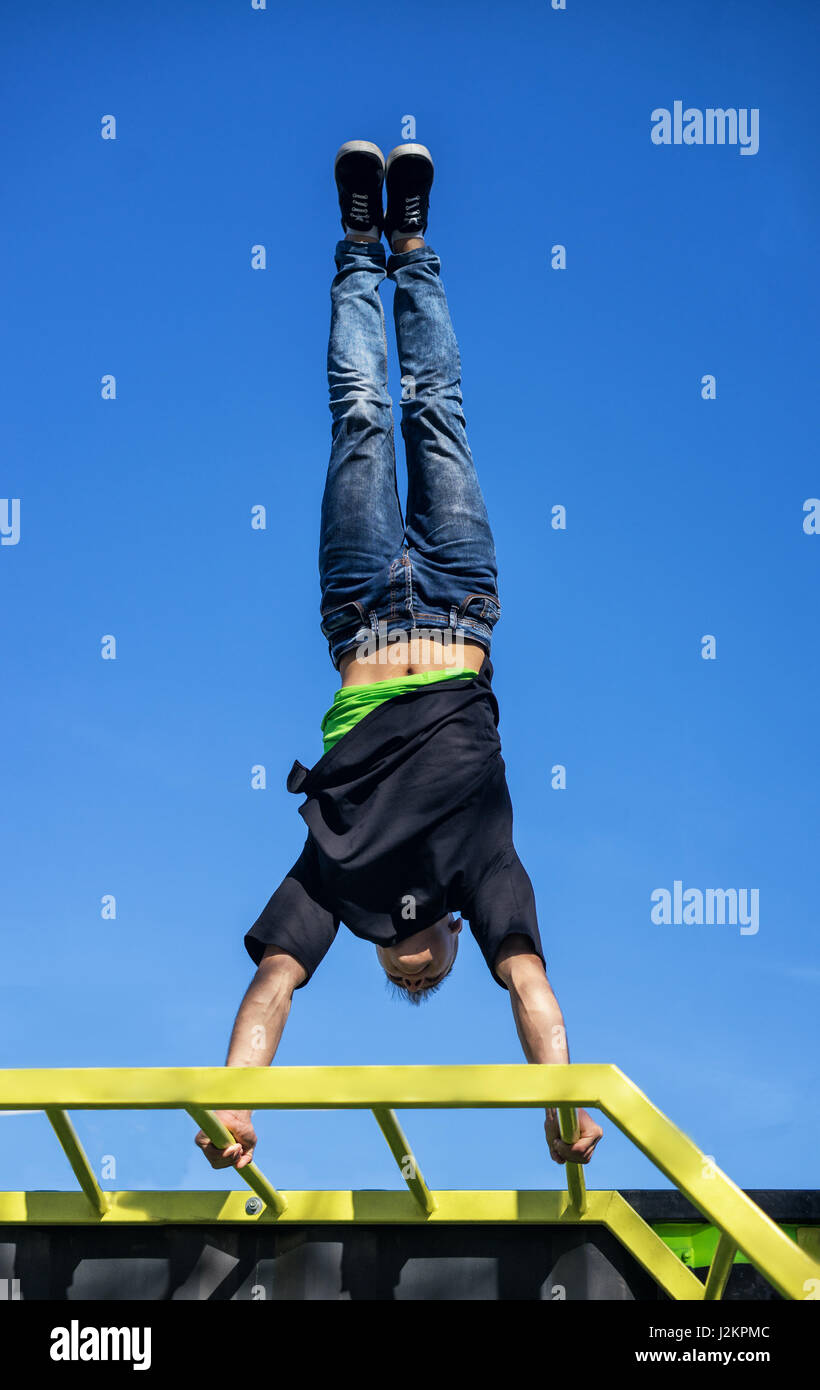 Young Athlete doing a Hand Stand On Parallel Bars In An Outdoor Gym ...