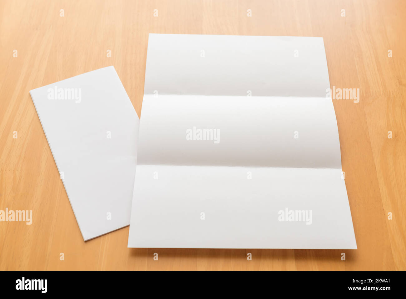 Trifold white template paper on wood background Stock Photo - Alamy