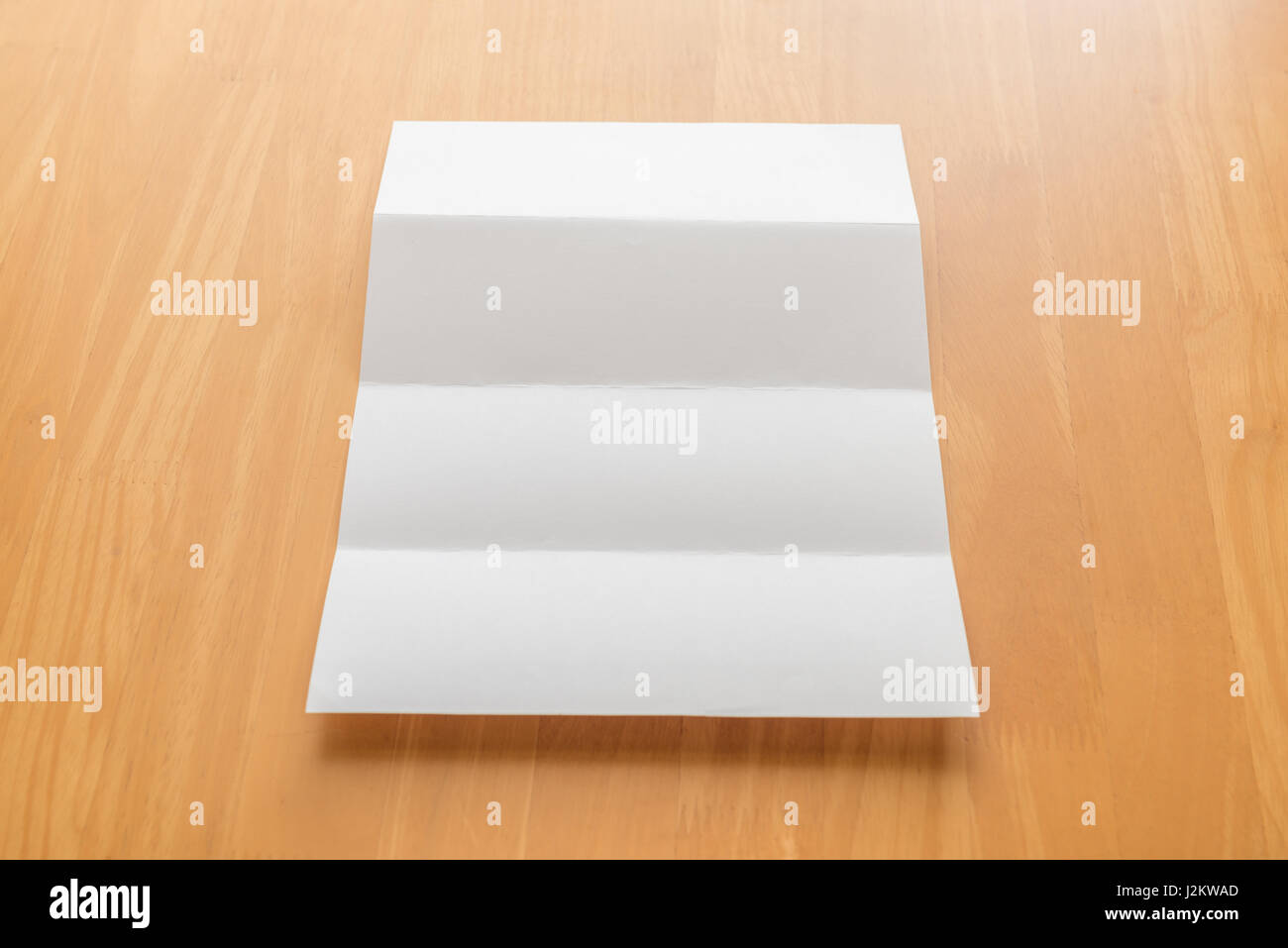 Four fold white template paper with wooden clipboard on wood background ...