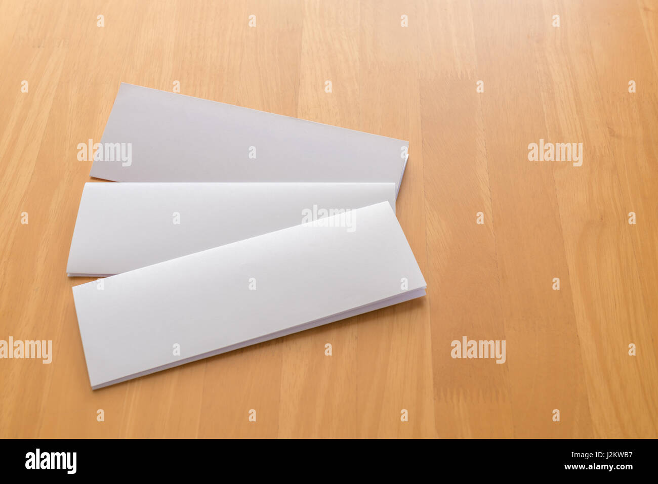 Four fold white template paper with wooden clipboard on wood background ...