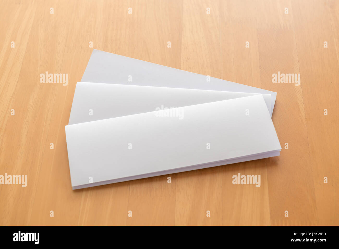 Four fold white template paper with wooden clipboard on wood background ...