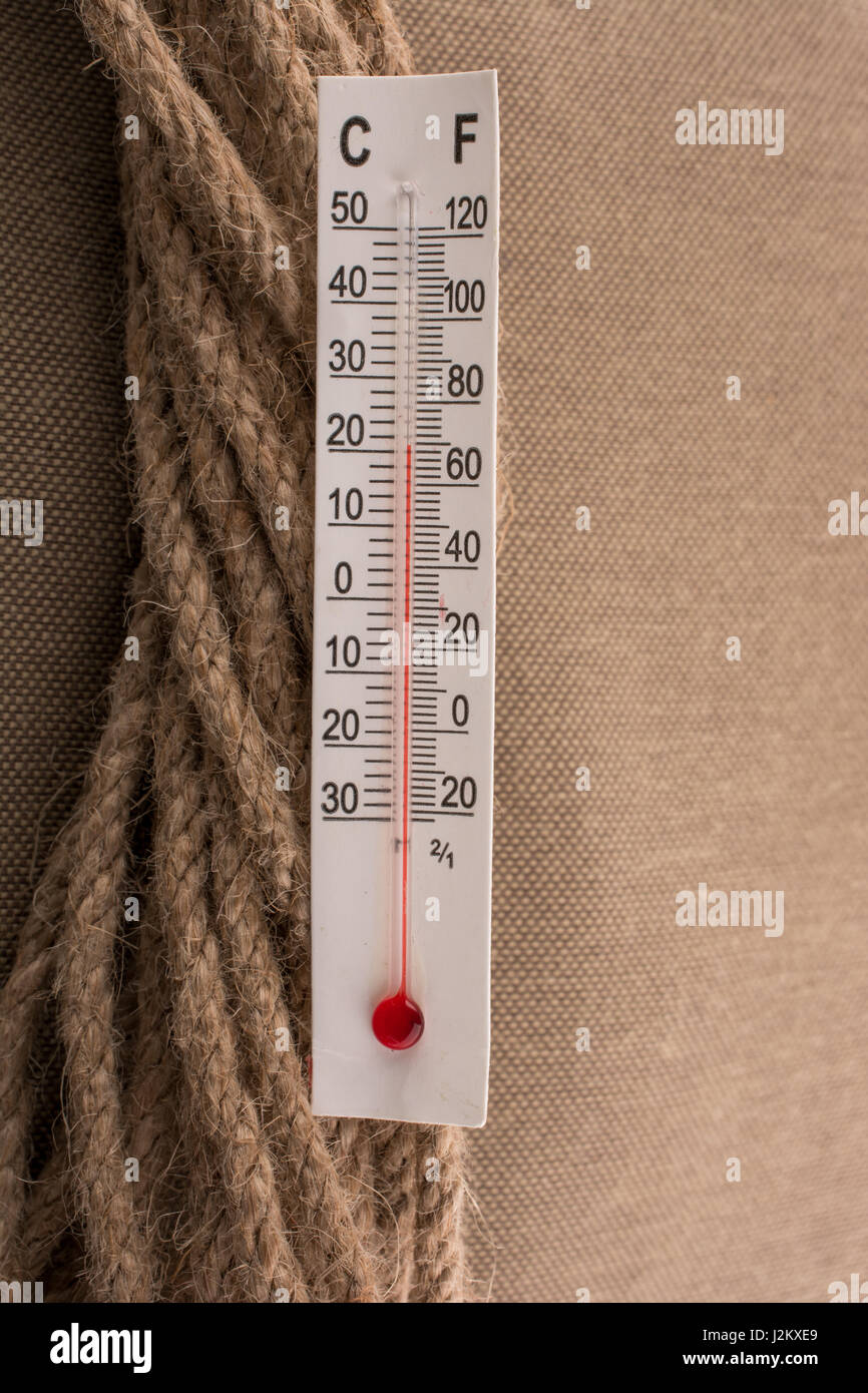 Thermometer placed on a brown rope on a fabric background Stock Photo ...