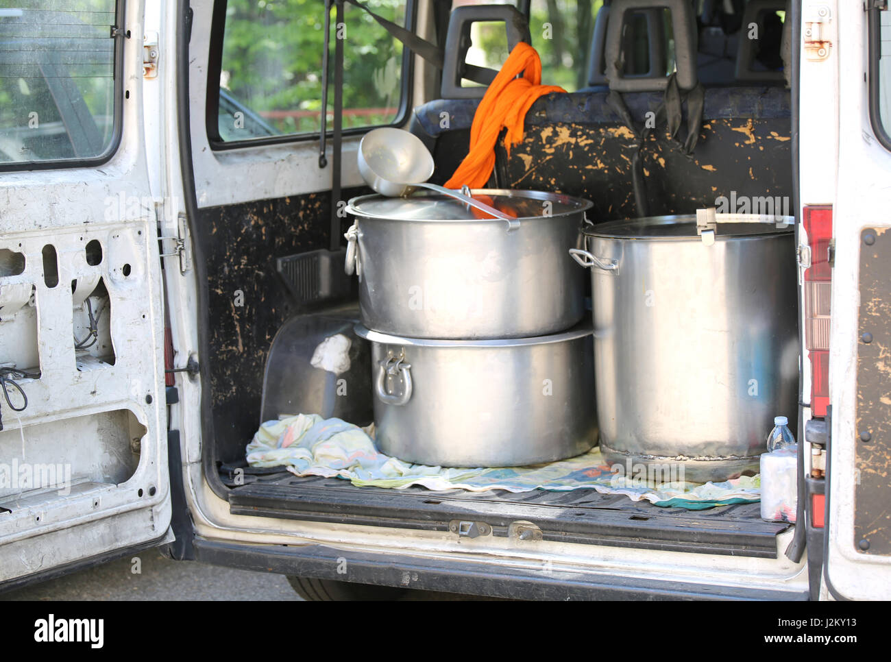 Pots for transporting food into the van trunk in a refugee camp for ...