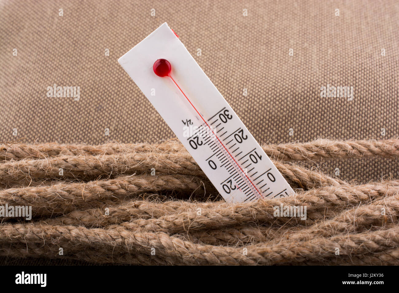 Thermometer placed on a brown rope on a fabric background Stock Photo ...