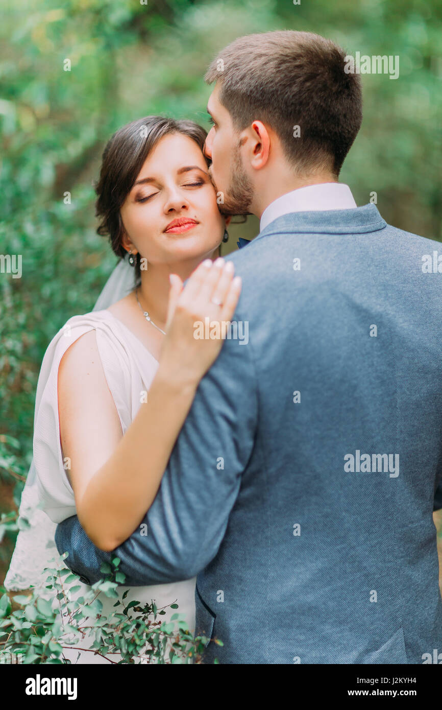 Sensual bride leaning to shoulder of her loving groom. Wedding pair ...