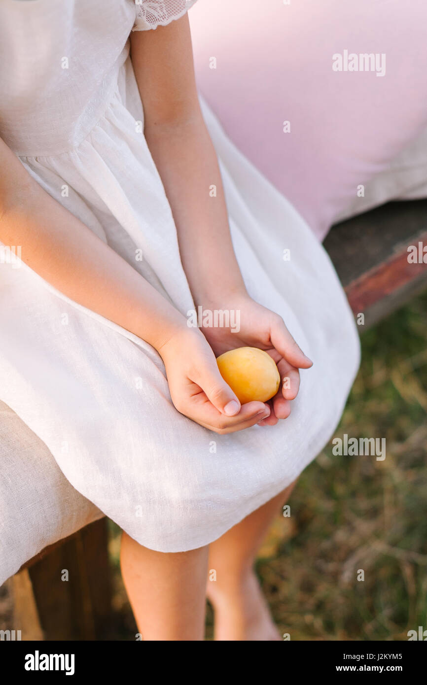 people, food, holiday concept - two hands of a little girl in a white ...