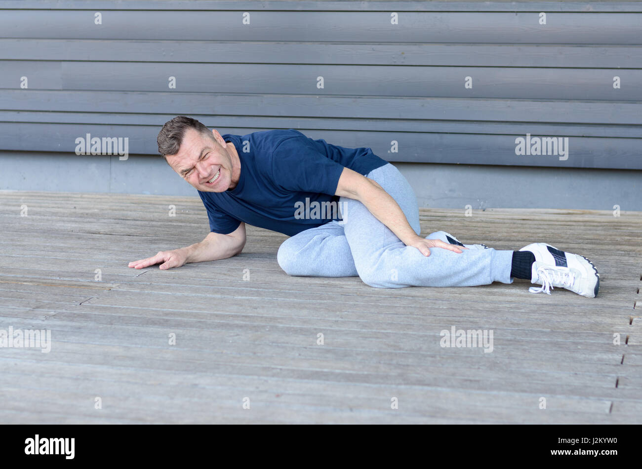 Sporty middle-aged man with muscle cramps in his calf lying on the ...