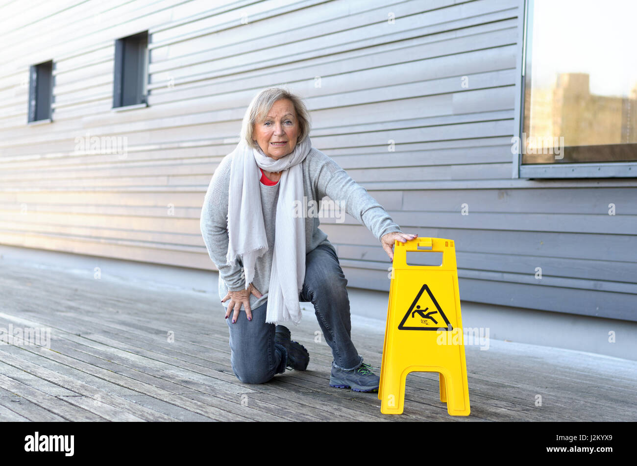 Elderly woman crawling on her knees and grimacing in pain after ...