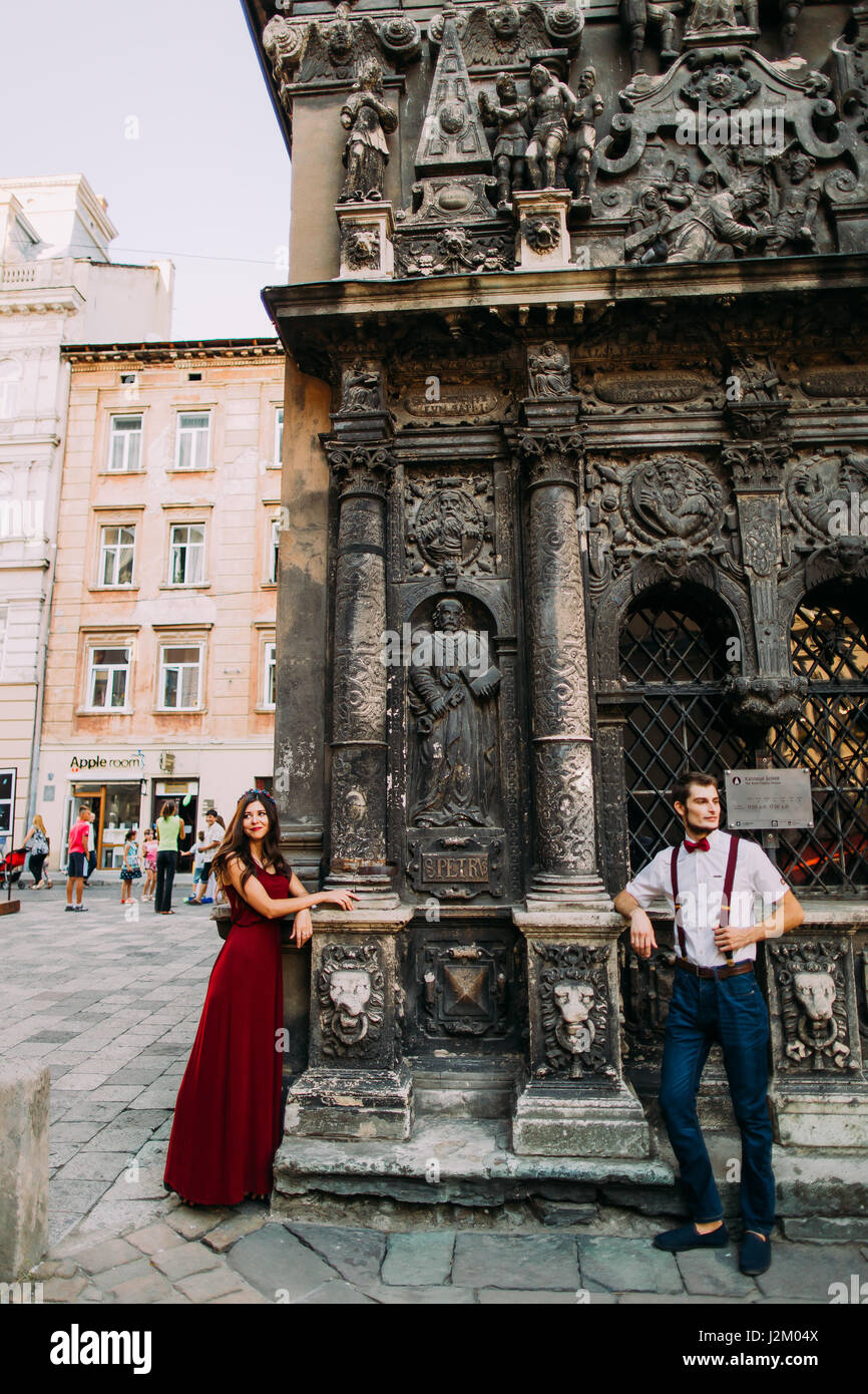 Stylish luxury dressed couple posing at the old bas-relief on chapel of ...