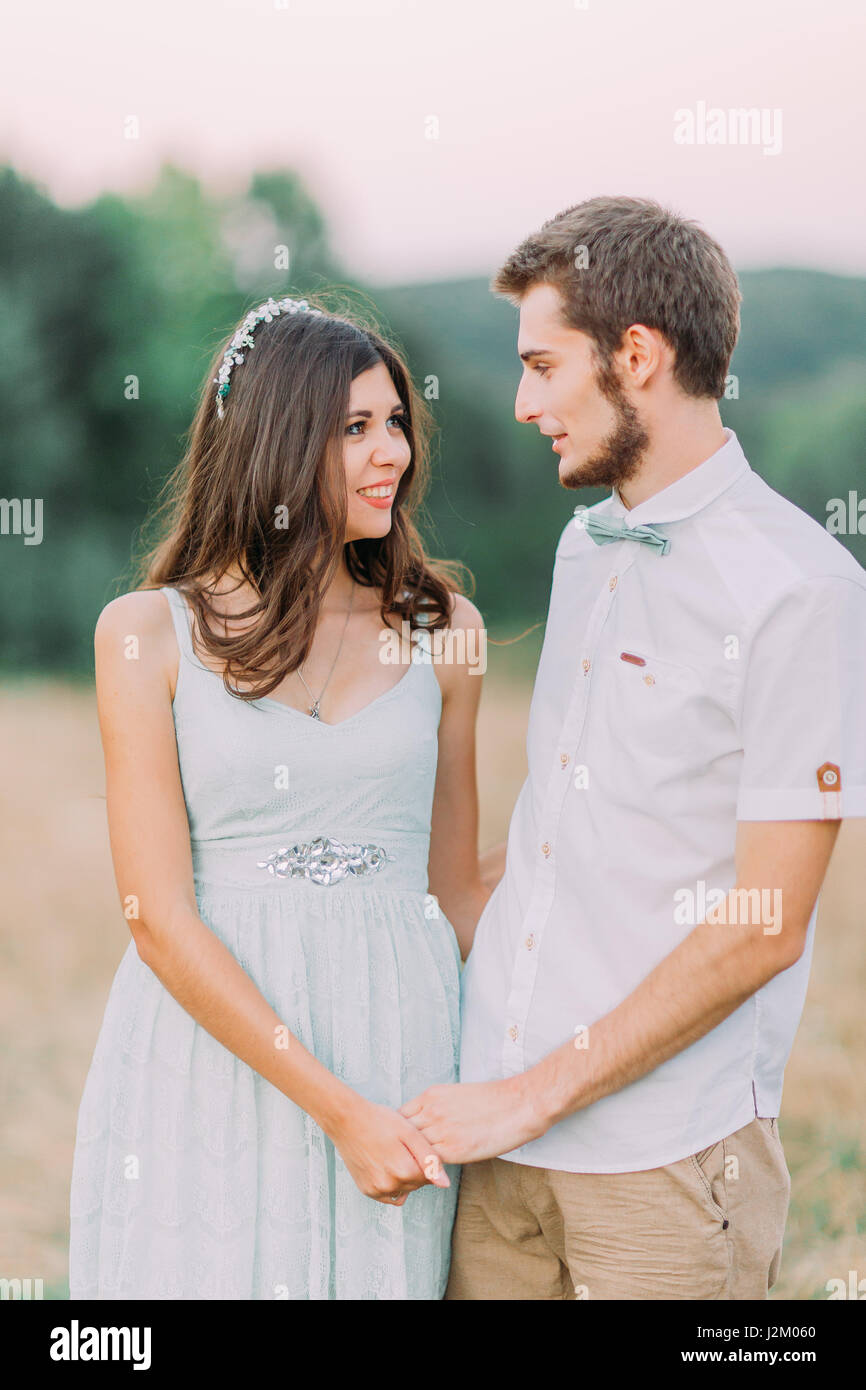 Portrait of young happy stylish couple lovingly look at each other on ...