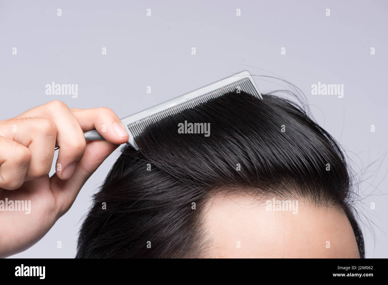 Close up photo of clean healthy man's hair. Young man comb his hair ...