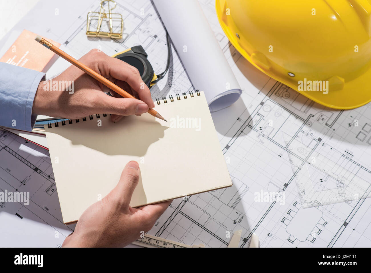 Working on blueprints. Construction project with hands writing on ...
