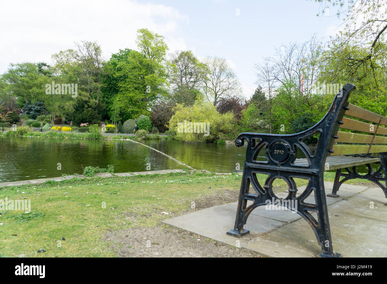 Park bench by a lake in a park in the springtime Stock Photo - Alamy