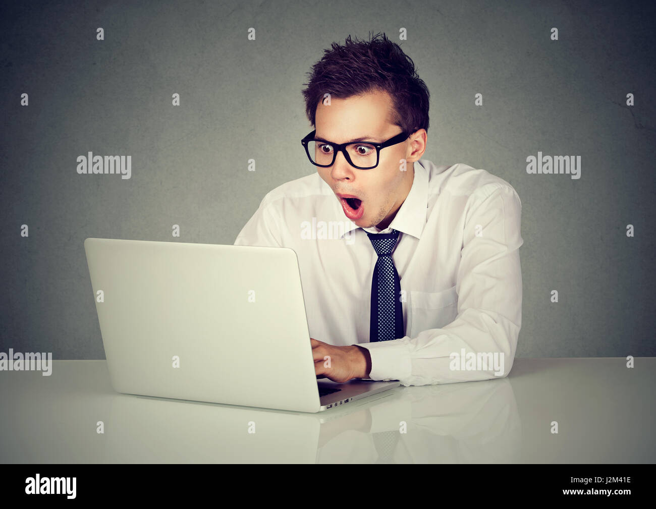 Surprised man using a laptop computer Stock Photo - Alamy