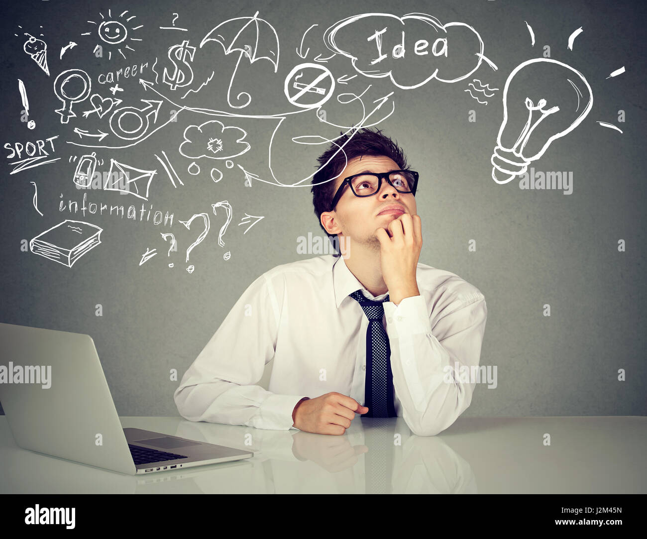 Business man sitting at table with laptop has many ideas planning ...