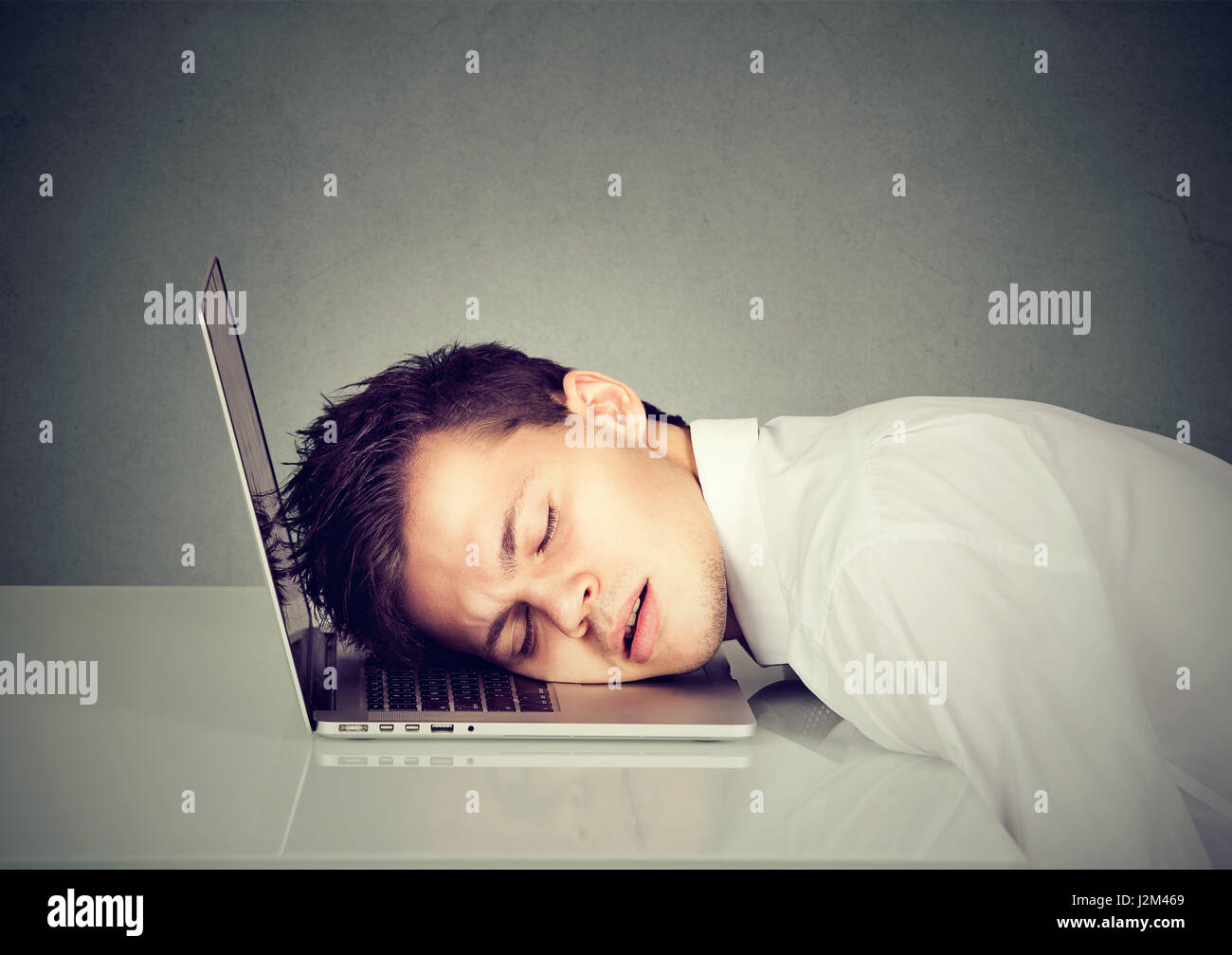 Young business man sleeping on his laptop Stock Photo - Alamy