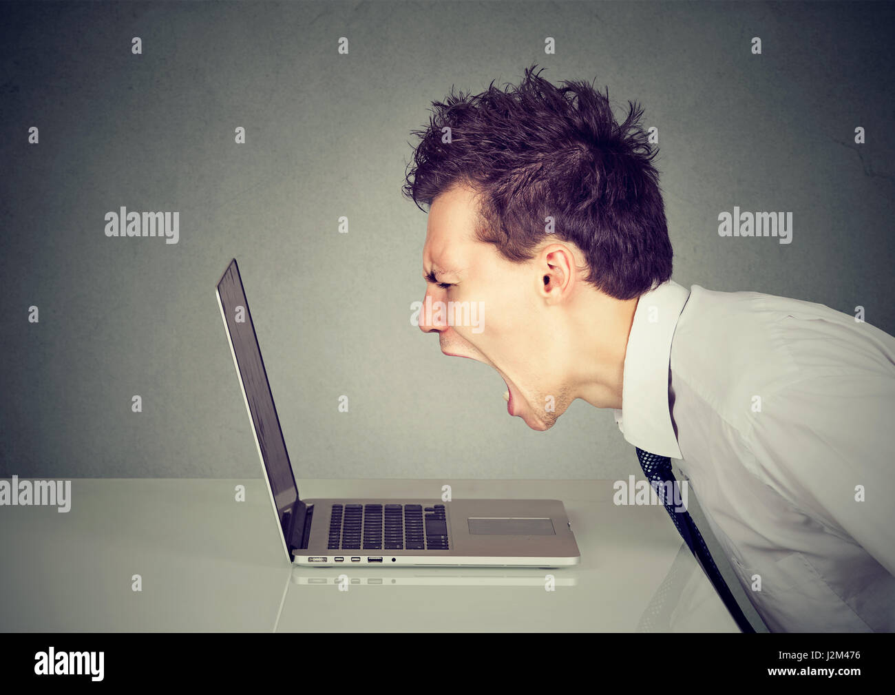 angry businessman working on laptop Stock Photo - Alamy