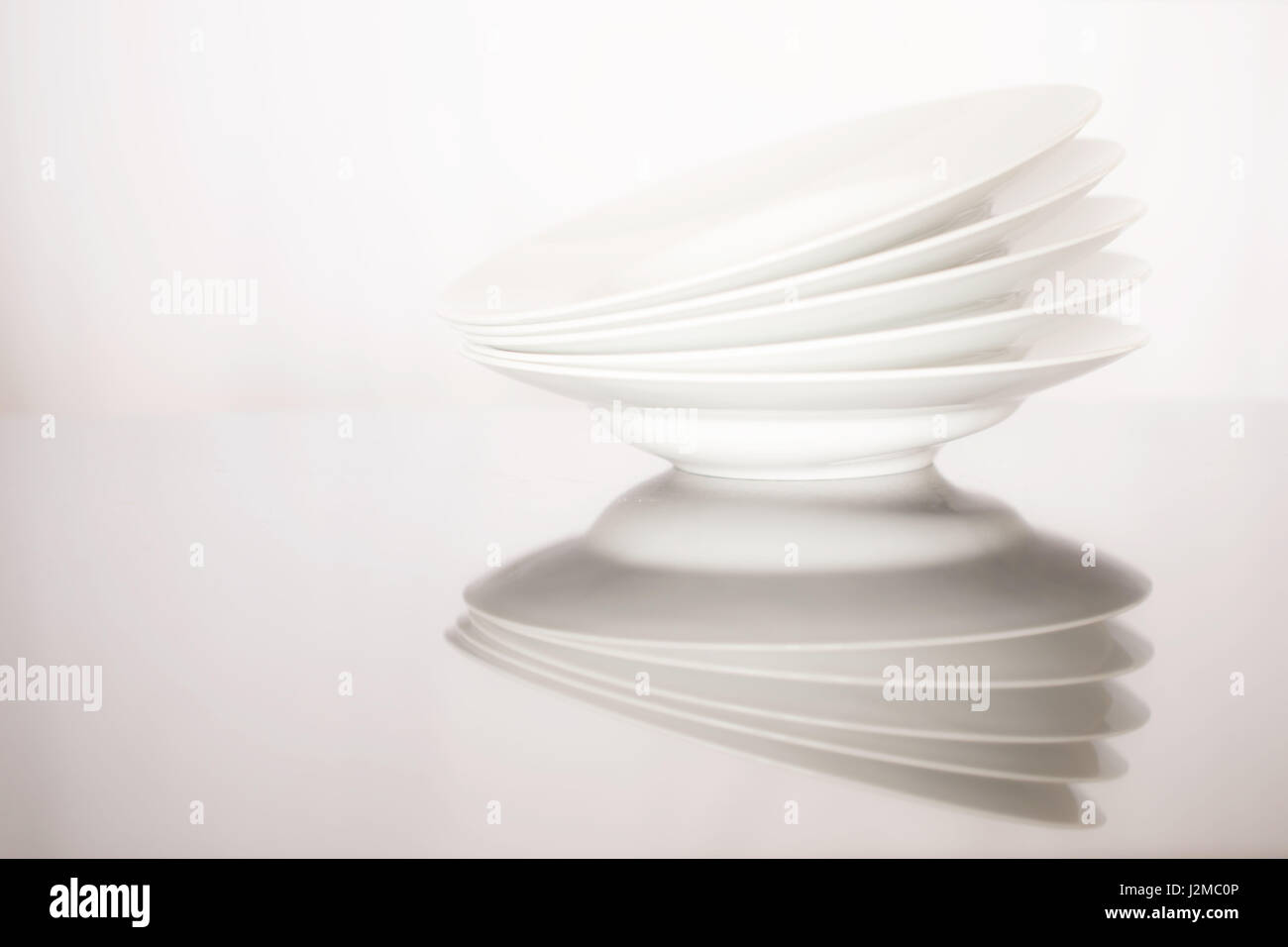 Stack of white plates with reflections Stock Photo - Alamy