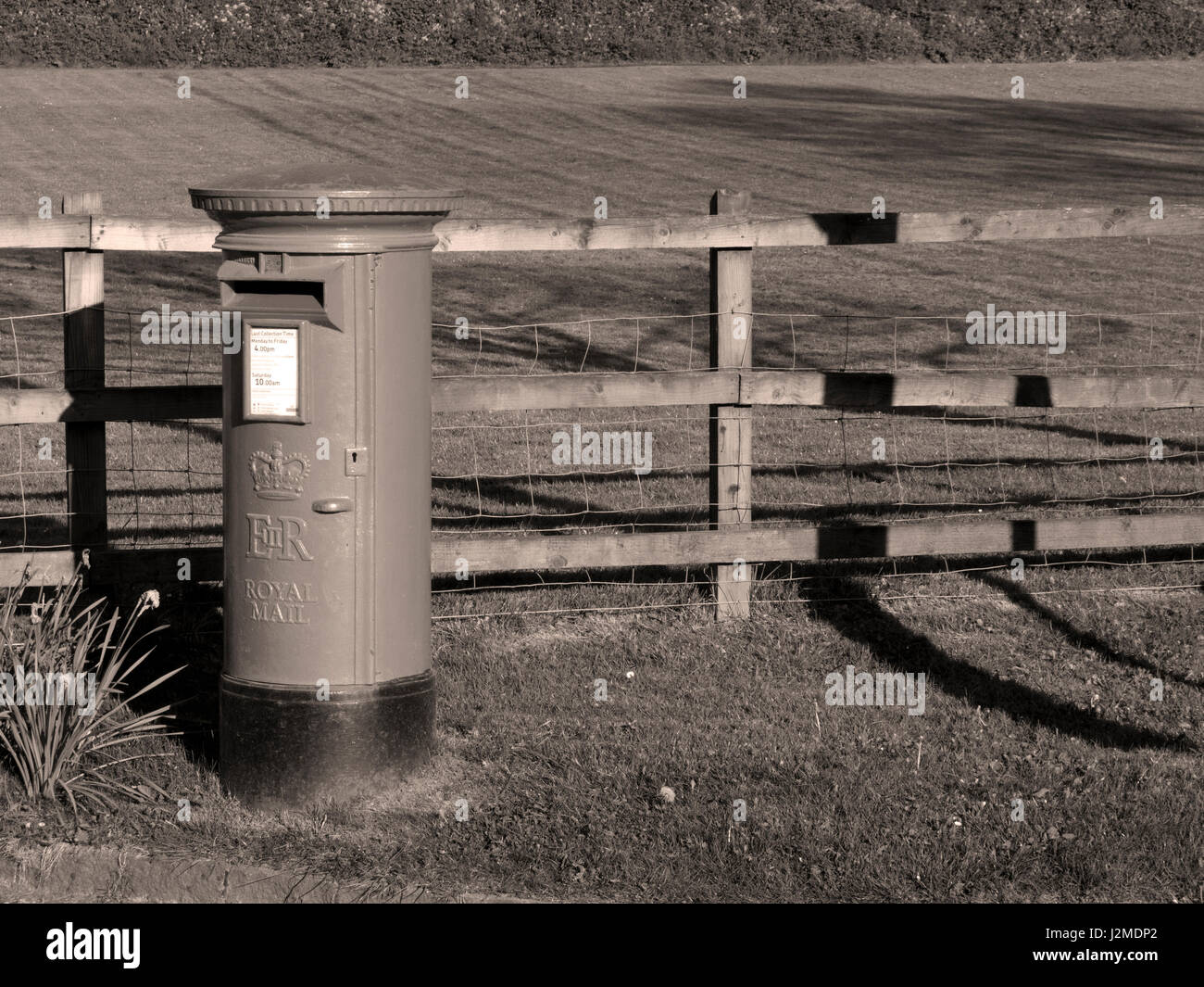 Sepia Royal Mail postbox in countryside rural setting with village ...