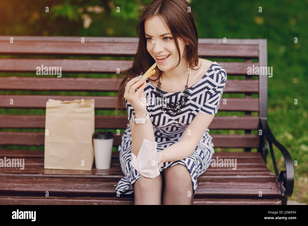young model enjoying the break and eating fries Stock Photo - Alamy