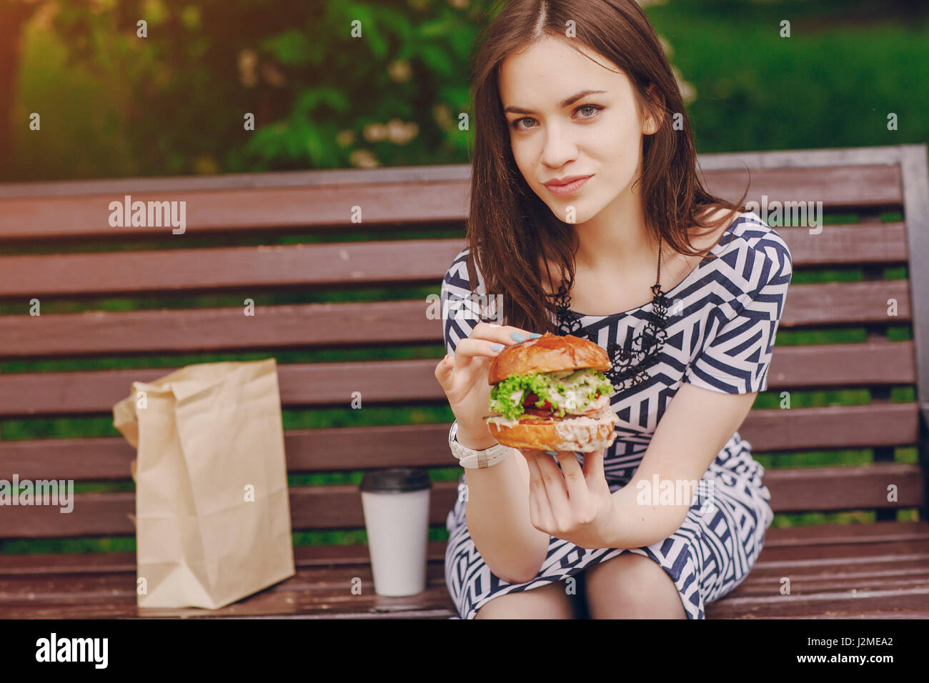 young model enjoying the break and eating a Burger Stock Photo - Alamy