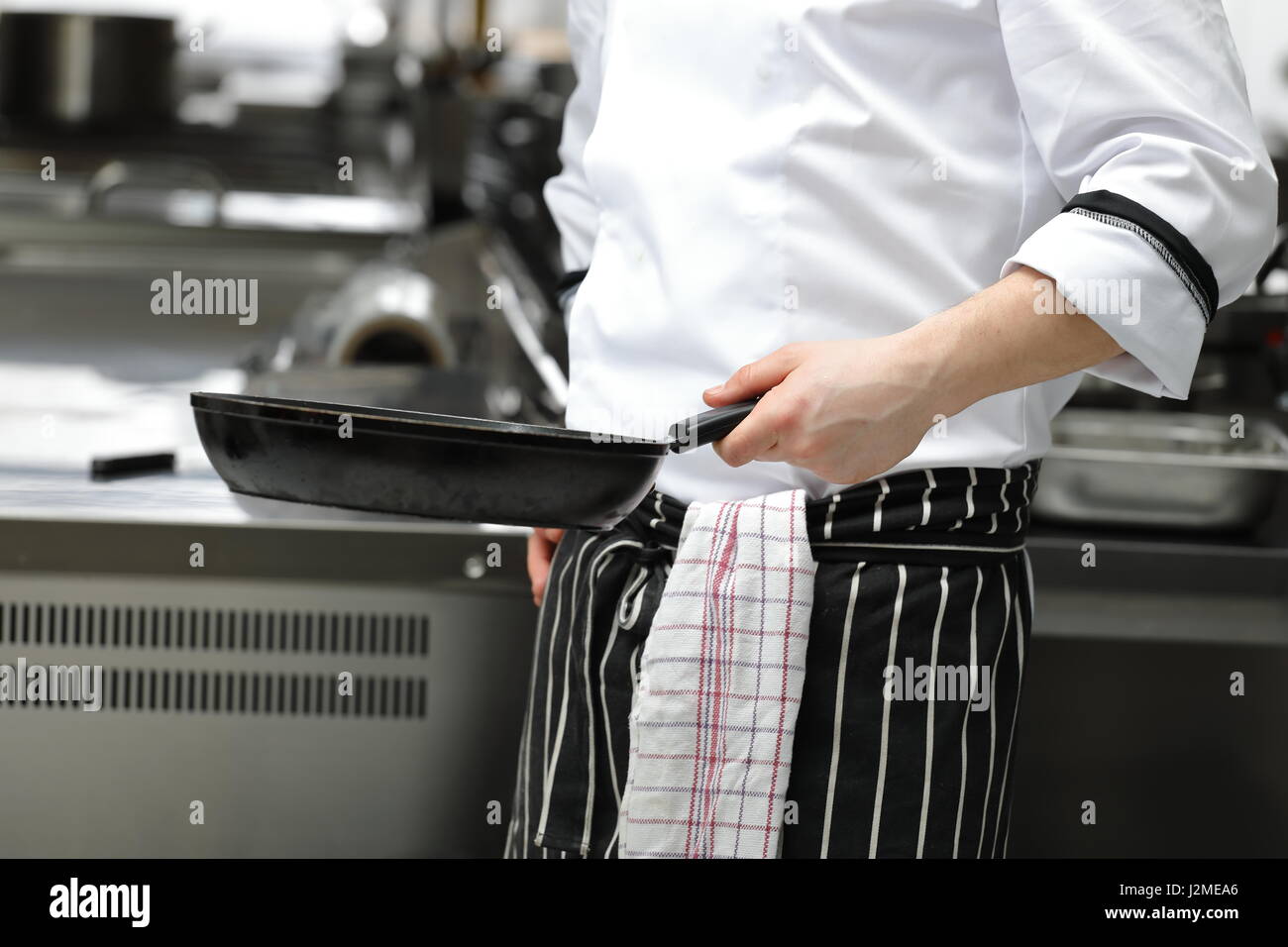 Chef in hotel or restaurant kitchen cooking Stock Photo - Alamy