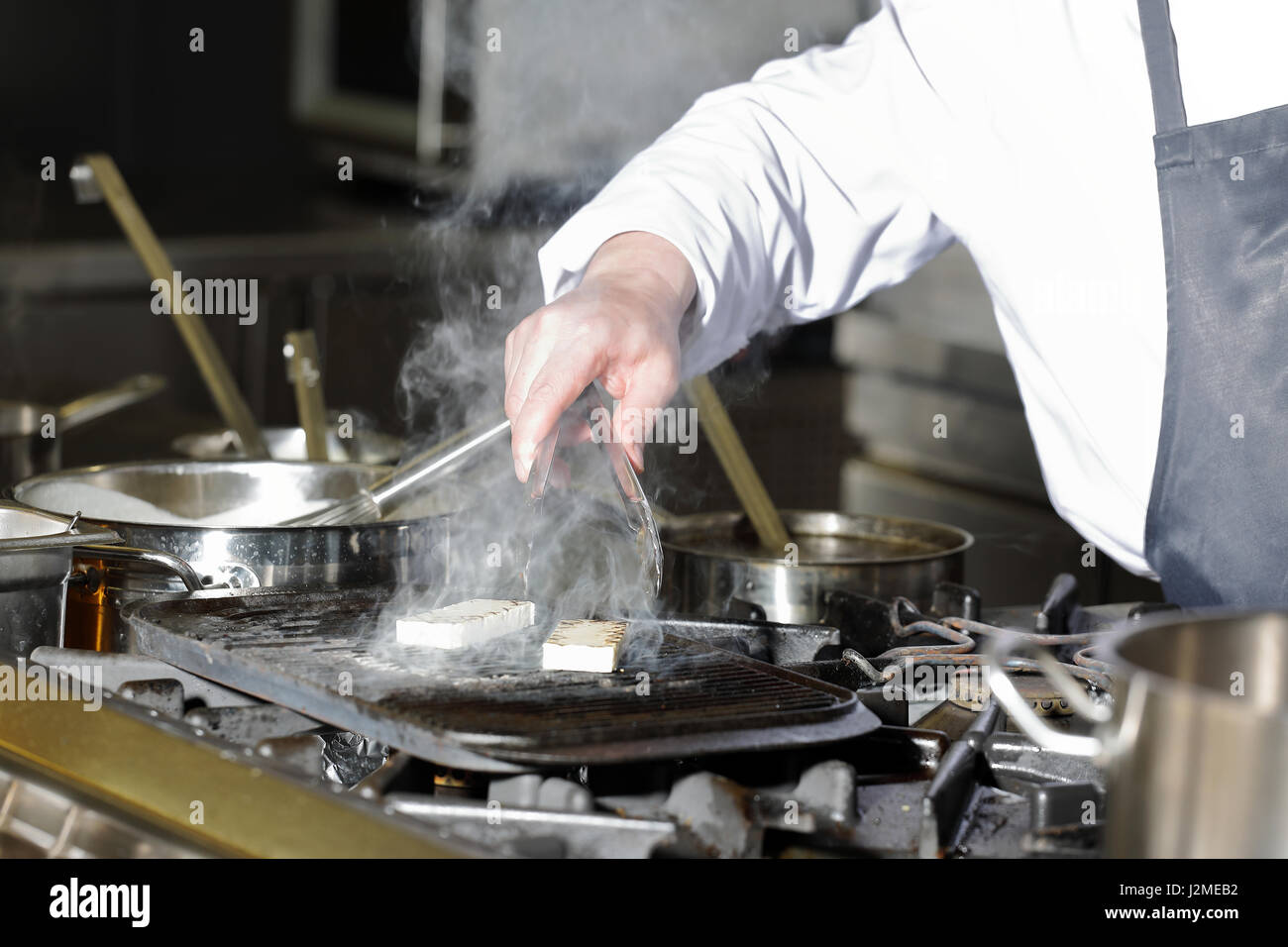 Chef in hotel or restaurant kitchen cooking Stock Photo - Alamy