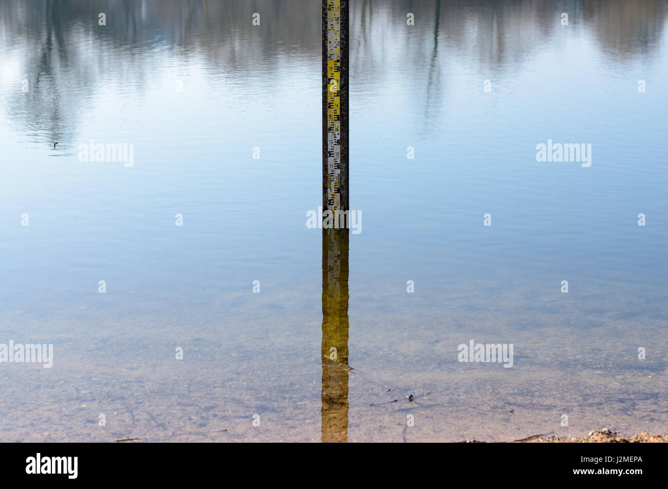 Flood level or water depth scale pillar barely submerged reflecting in ...