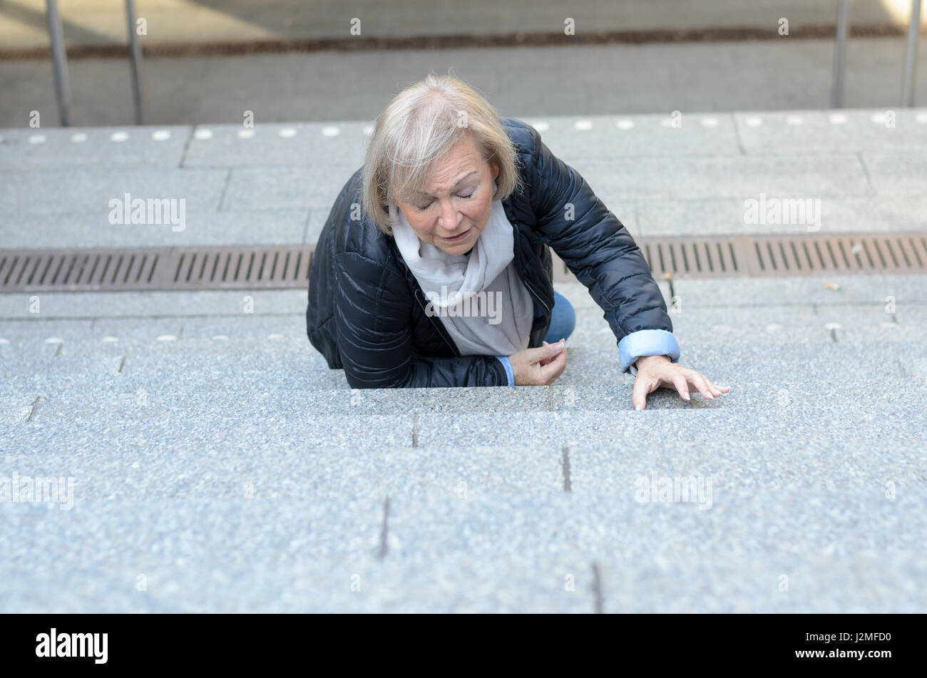Helpless senior woman falling down steps and looking down Stock Photo ...
