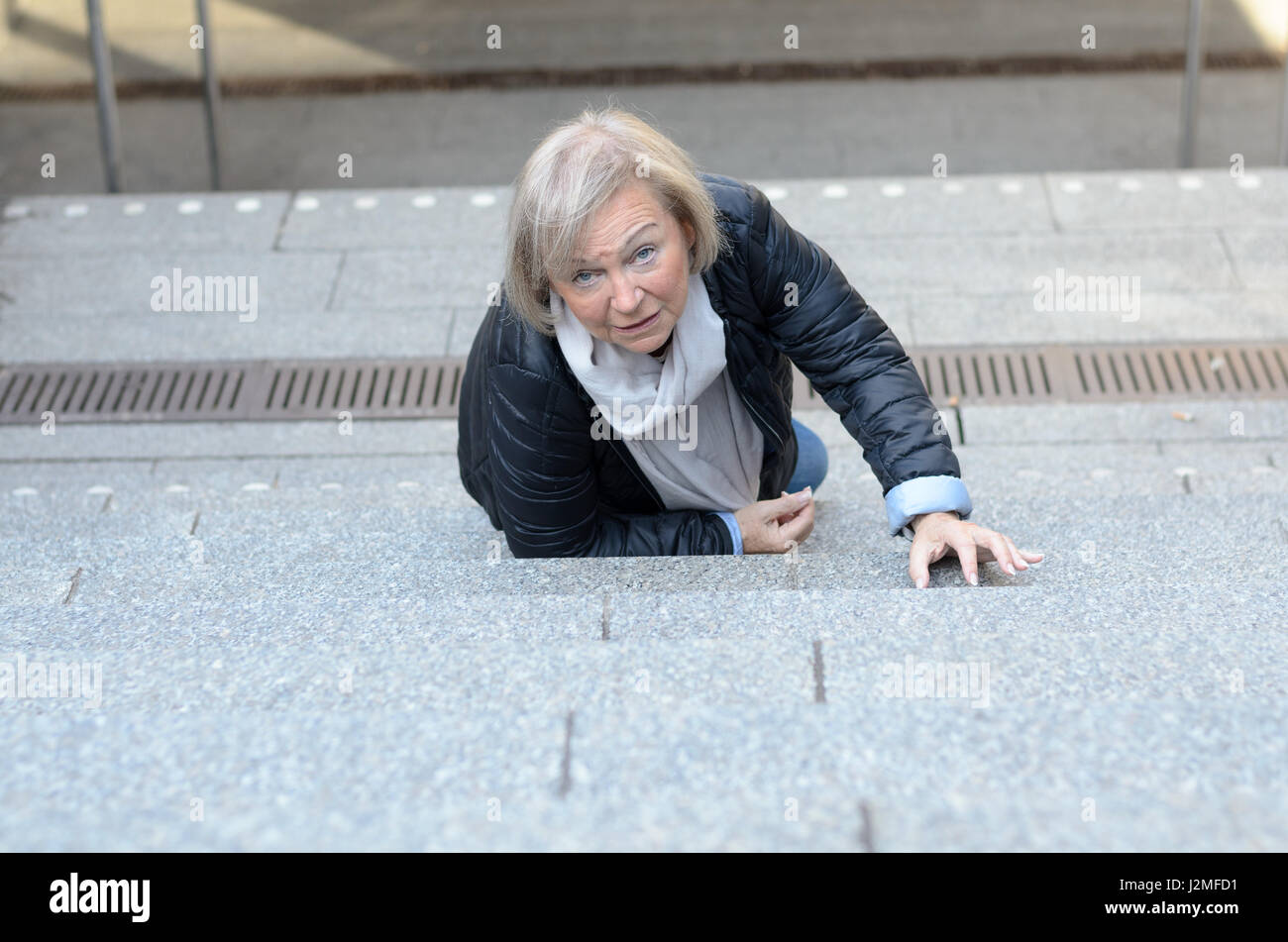 Helpless senior woman falling down steps and looking upwards Stock ...