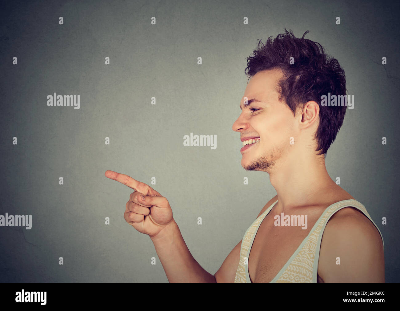 Look over there! Happy young man pointing with finger at someone or ...