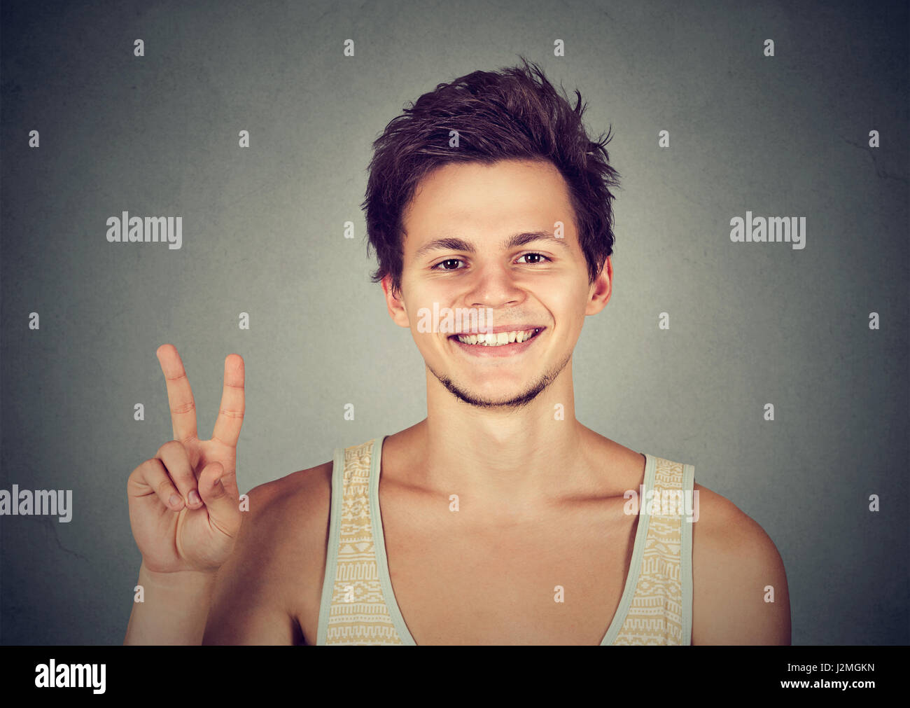 Young man, handsome student holding up peace victory, two sign isolated ...