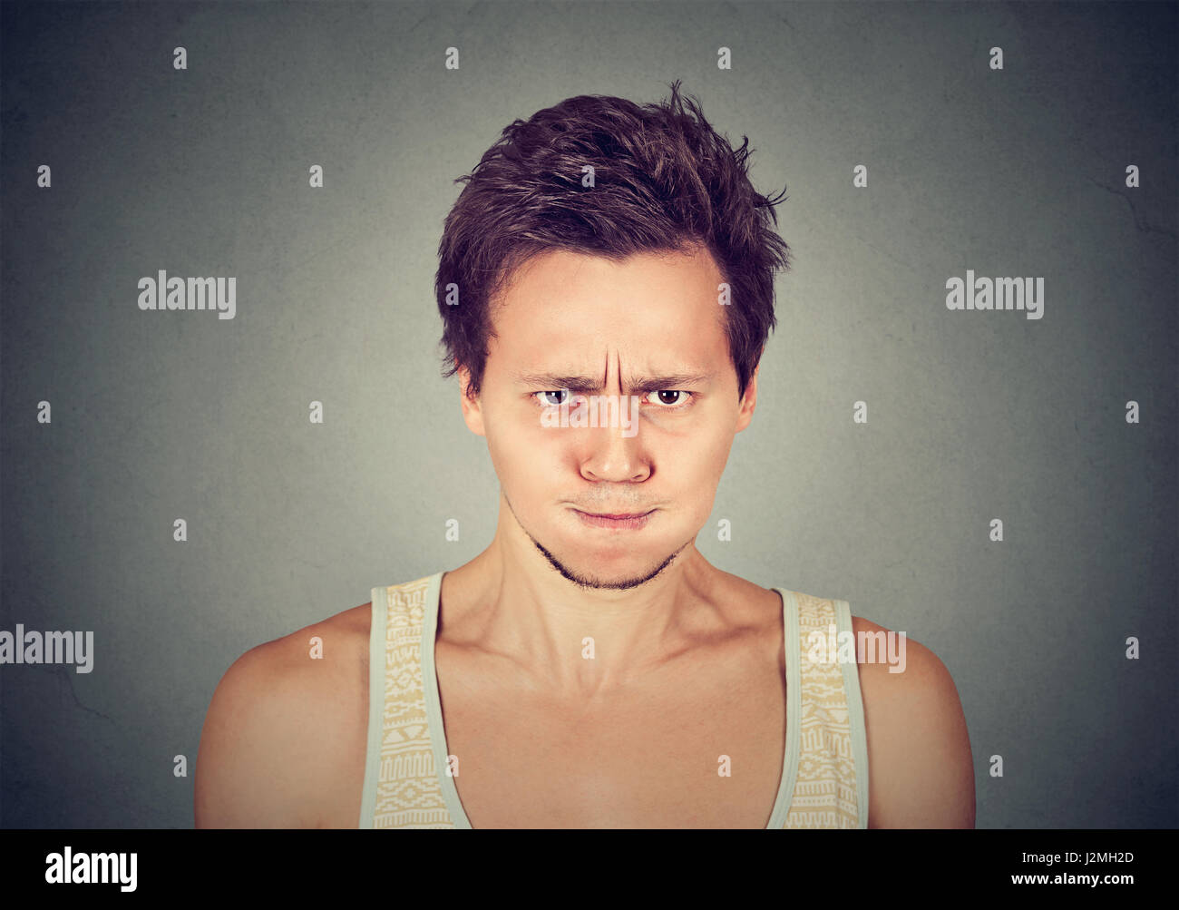 Angry young man about to have nervous breakdown isolated on gray ...