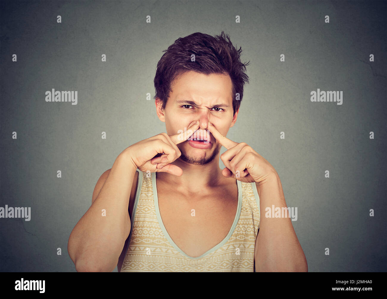 disgusted man pinches nose with fingers looks with disgust something ...