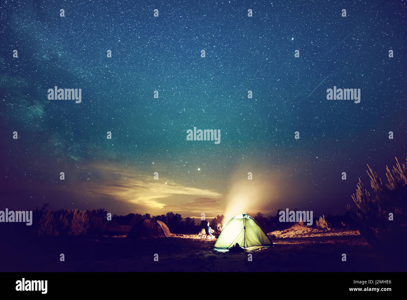 Camping fire under the amazing blue starry sky with a lot of shining ...